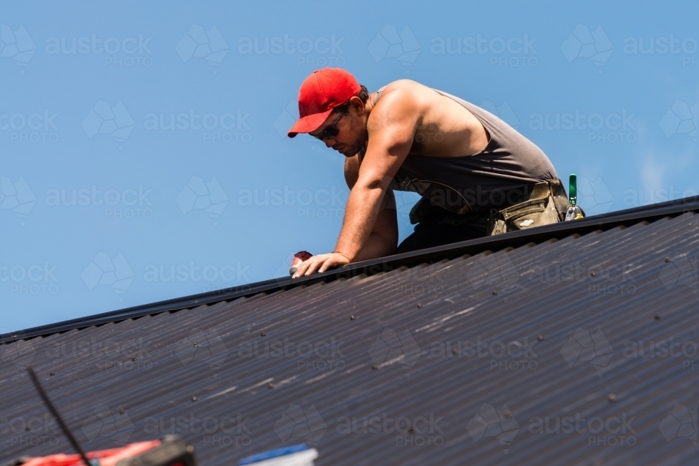 Image of tradie working on the roof - Austockphoto