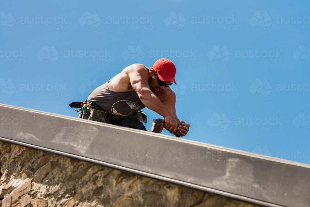 Image of tradie working on the roof - Austockphoto