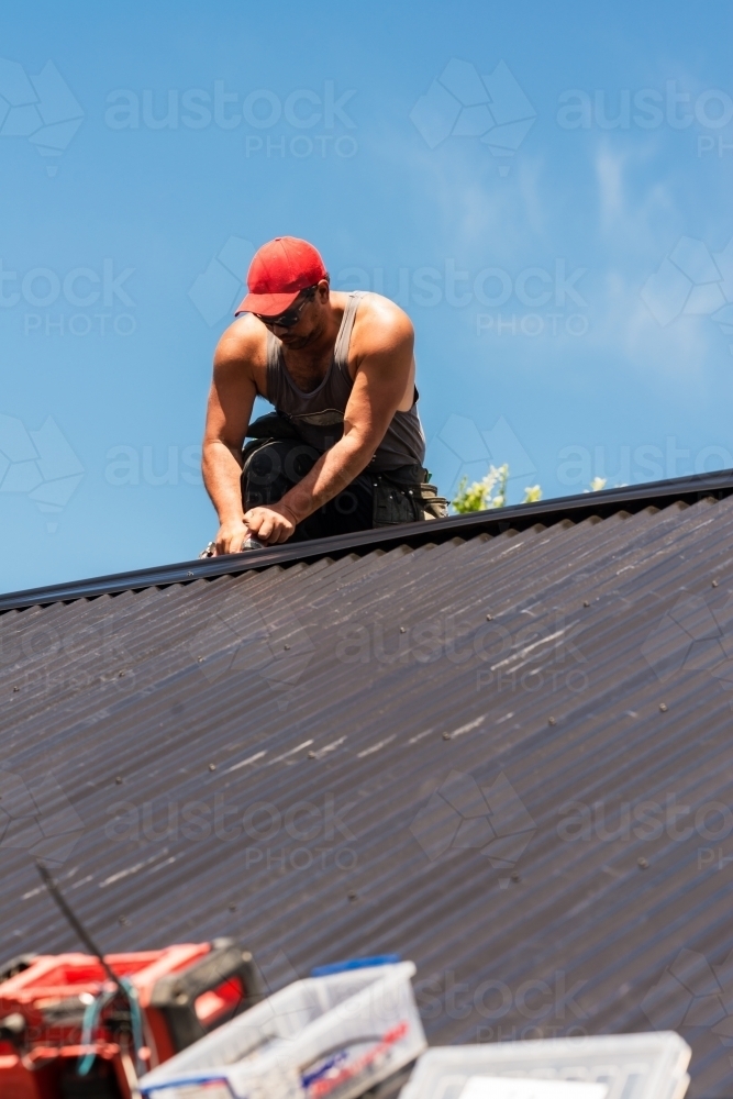 Image of tradie working on the roof - Austockphoto