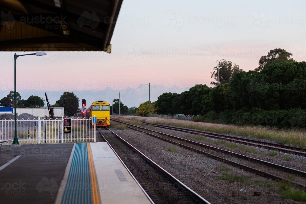 Image of Train coming into station late in the evening - Austockphoto