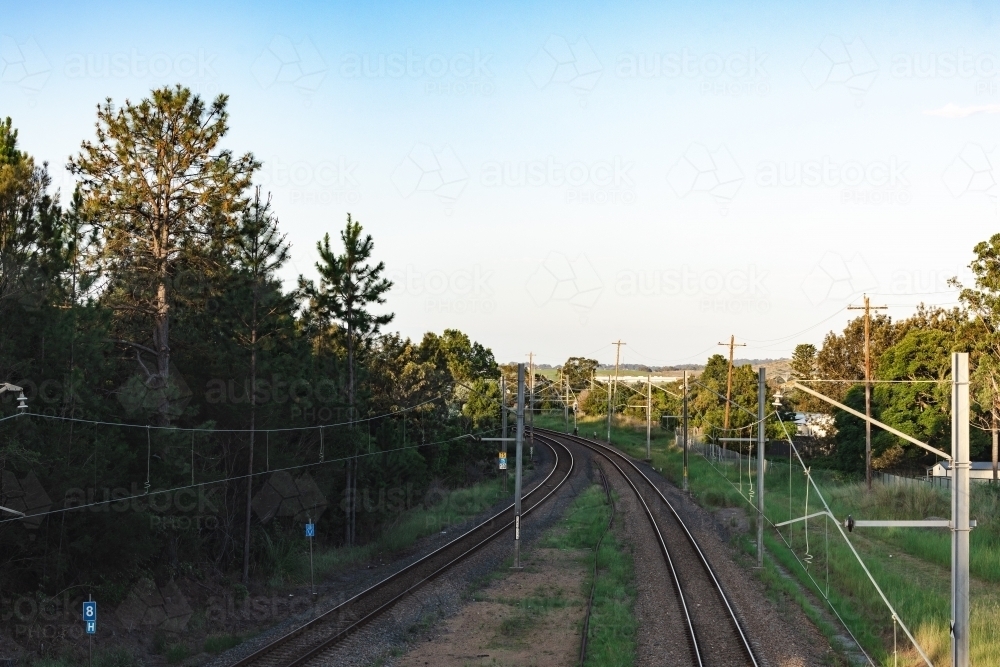 Image of Train tracks going around a bend surrounded by power lines ...