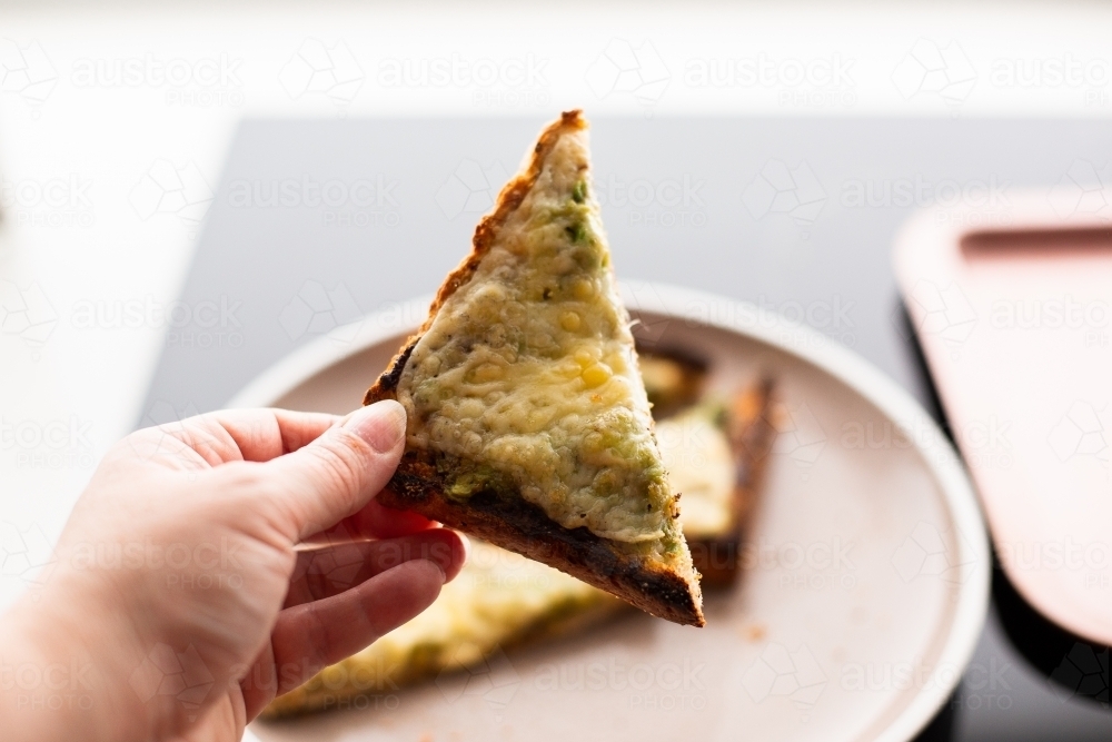Image of Triangle of cheesy avocado and vegemite toast - Austockphoto