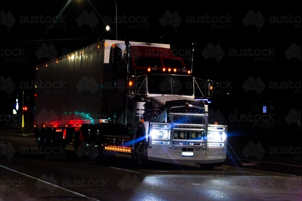 Image of truck driving on highway late at night transporting goods ...