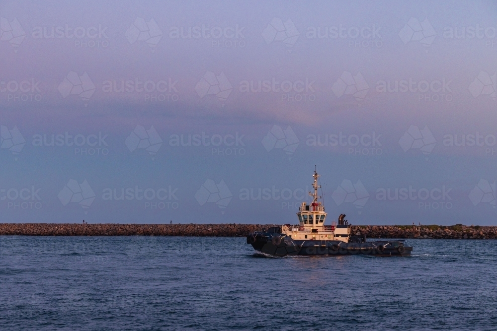 Image of Tugboat passing Nobbys Lighthouse on the headland at the ...