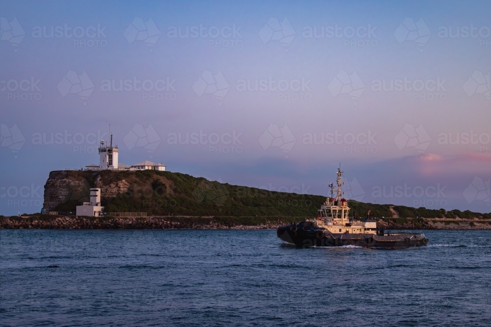 Image of Tugboat passing Nobbys Lighthouse on the headland at the ...