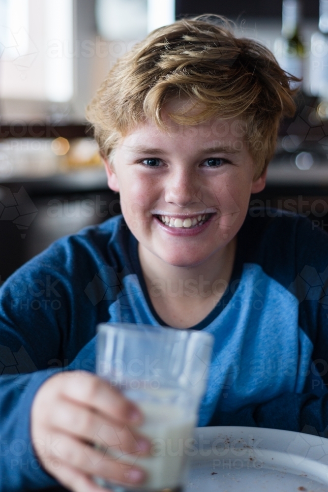 Image of tween boy enjoying toast and milk for breakfast - Austockphoto