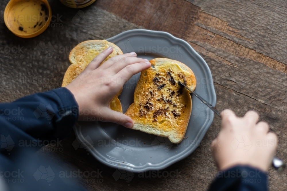 Image of tween girl making toast in the morning - Austockphoto