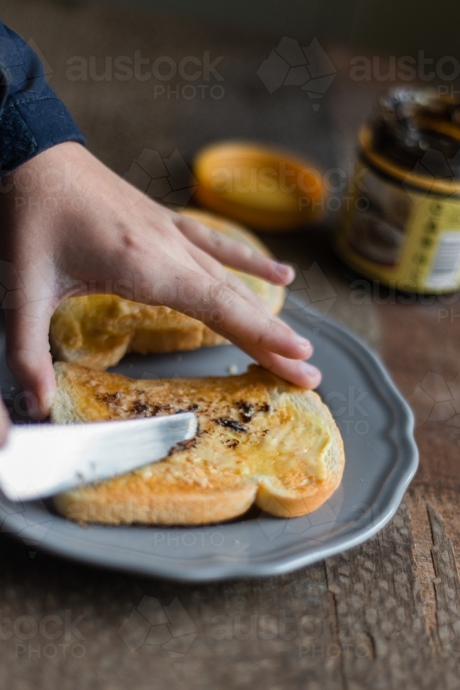 Image of tween girl making toast in the morning - Austockphoto