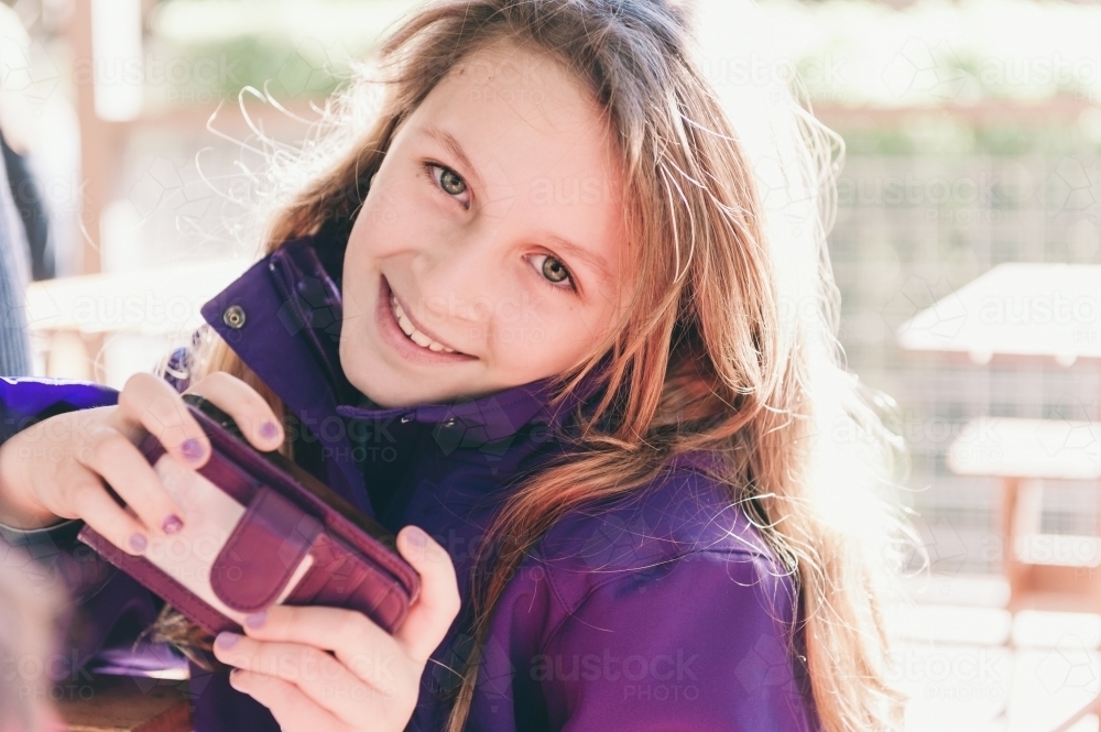 Image of tween girl with mobile phone, smiling to camera - Austockphoto