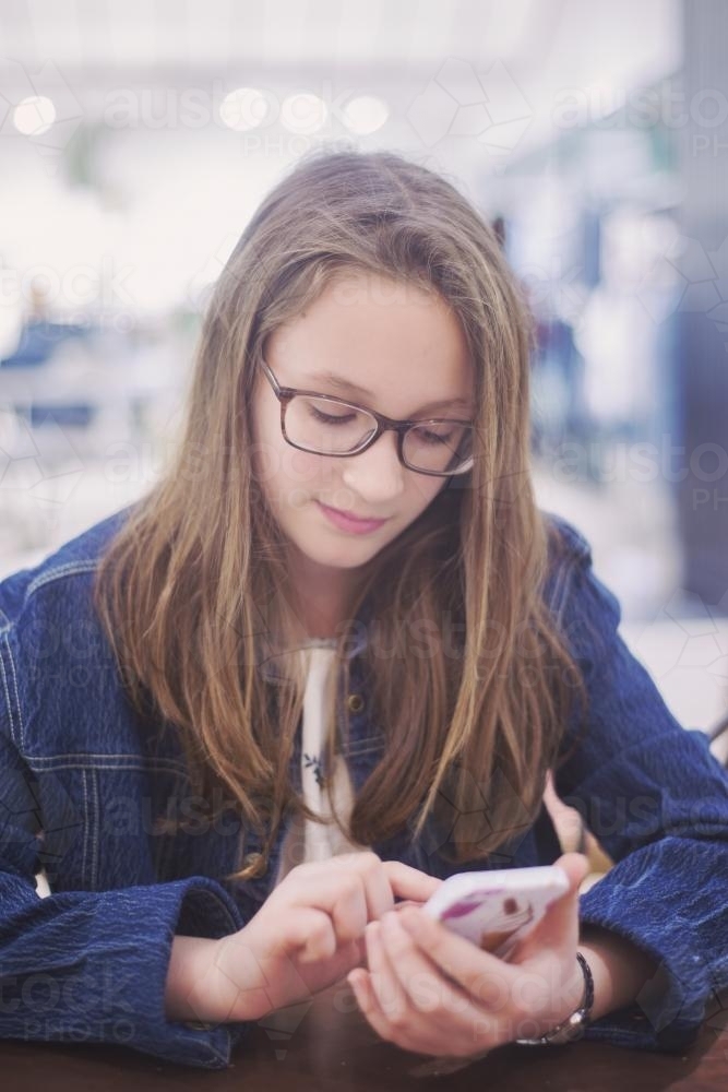 Image of tween girl with phone - Austockphoto