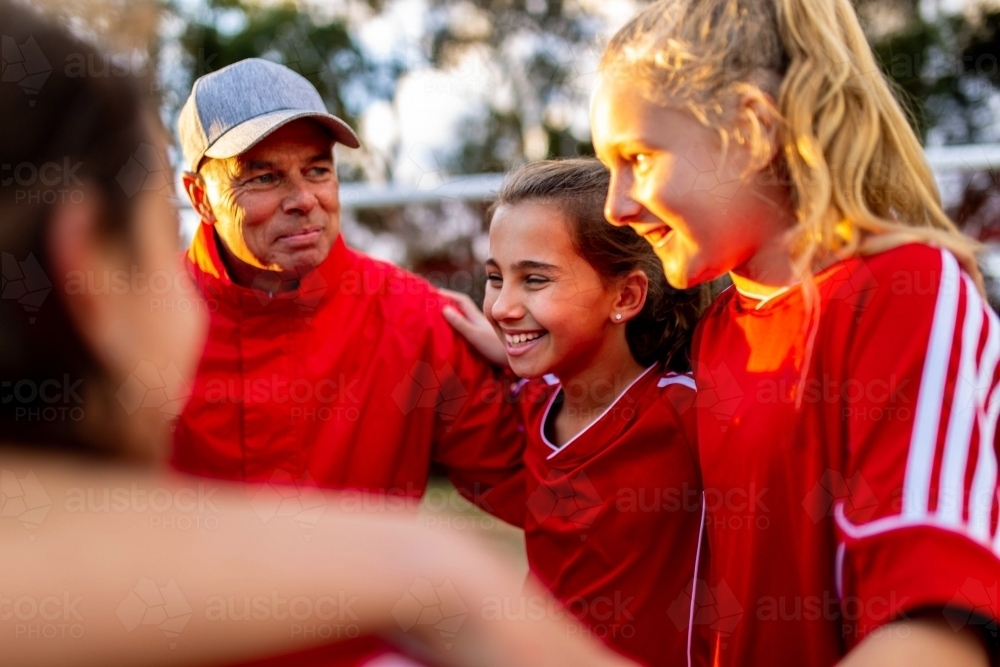 Image of Tween girls football team members in a close pre-game huddle ...
