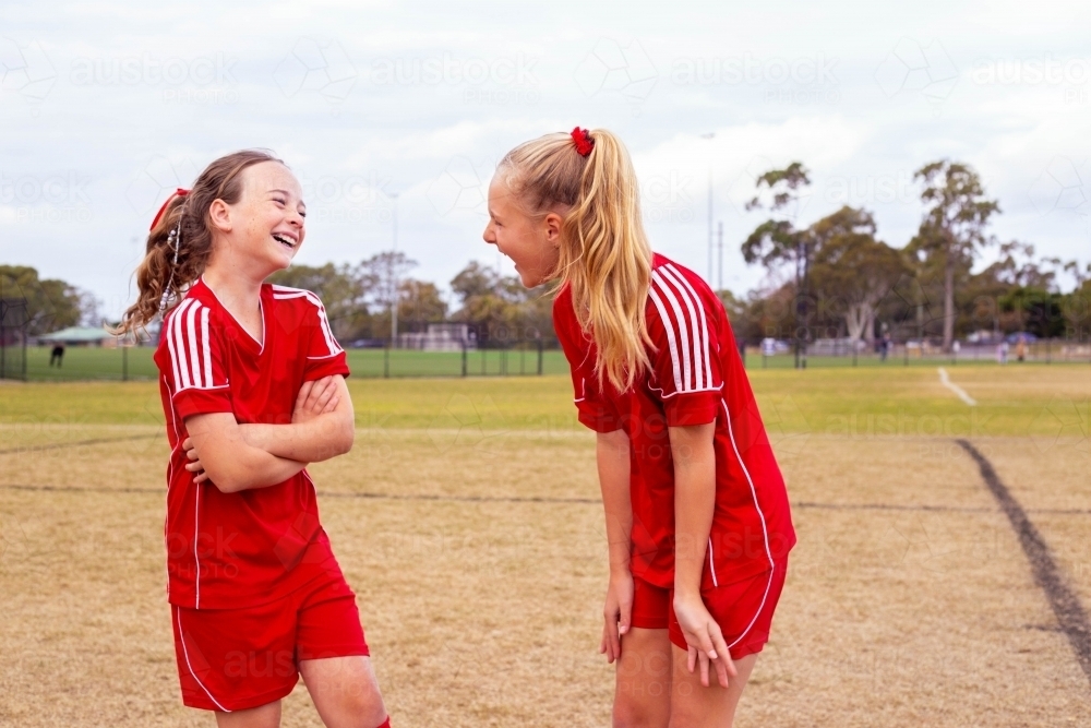 Image of Tween girls from the same football team laughing together ...