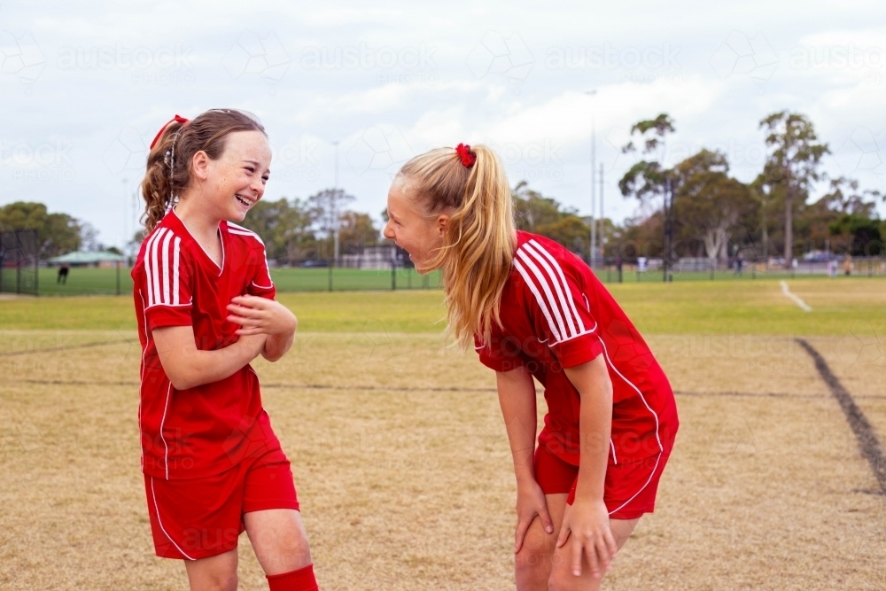 Image of Tween girls from the same football team laughing together ...