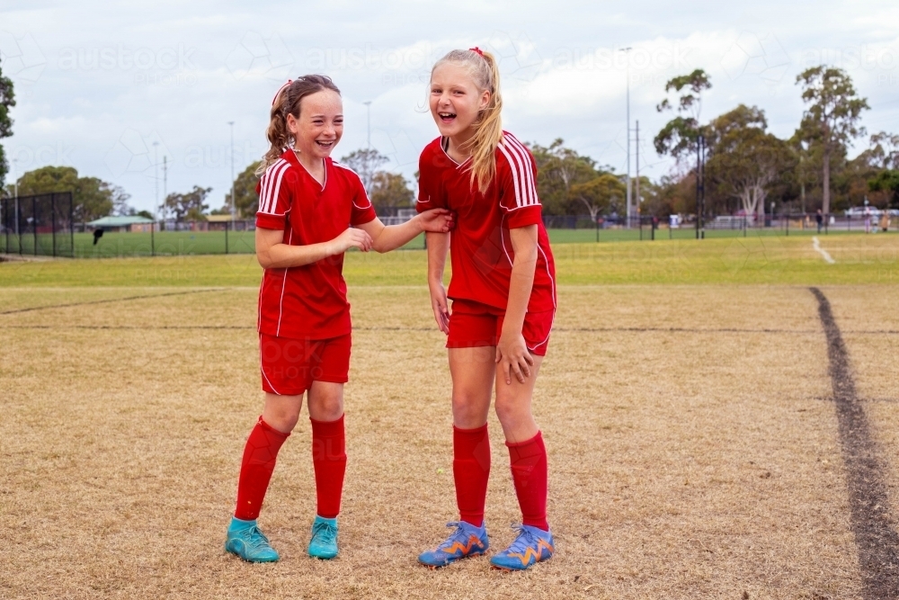 Image of Tween girls from the same football team laughing together ...