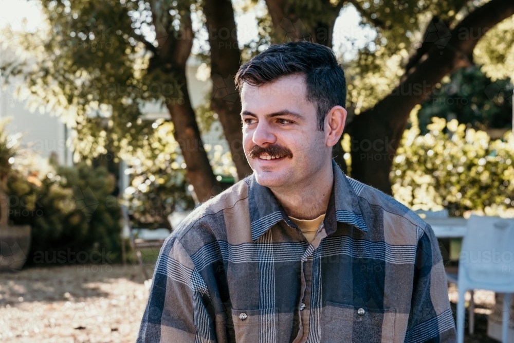 Image of Twenty something male smiles and looks sideways. - Austockphoto