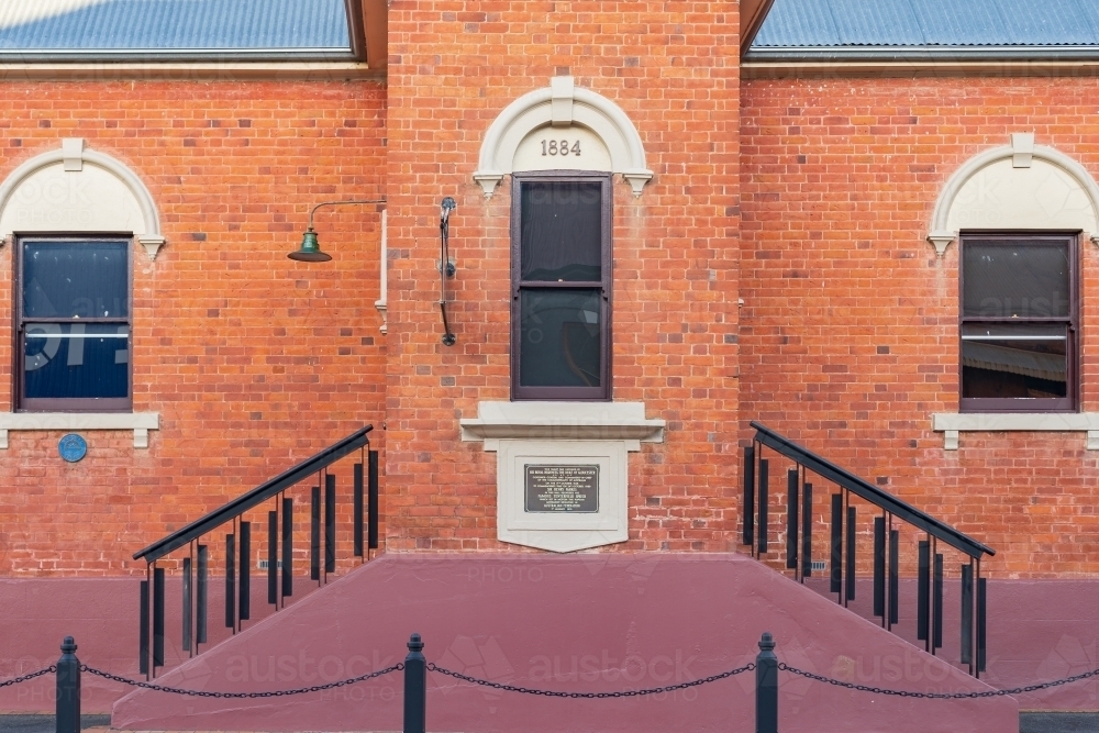 Image of Twin staircases leading up to an historic red brick courthouse ...