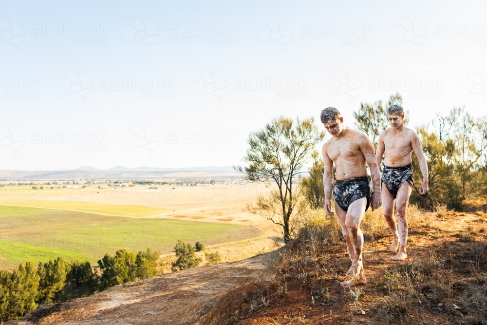 Image of Two Aboriginal Australians on country walking along the edge ...