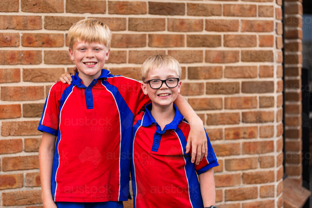Image of Two Australian boys in red and blue school uniforms - Austockphoto