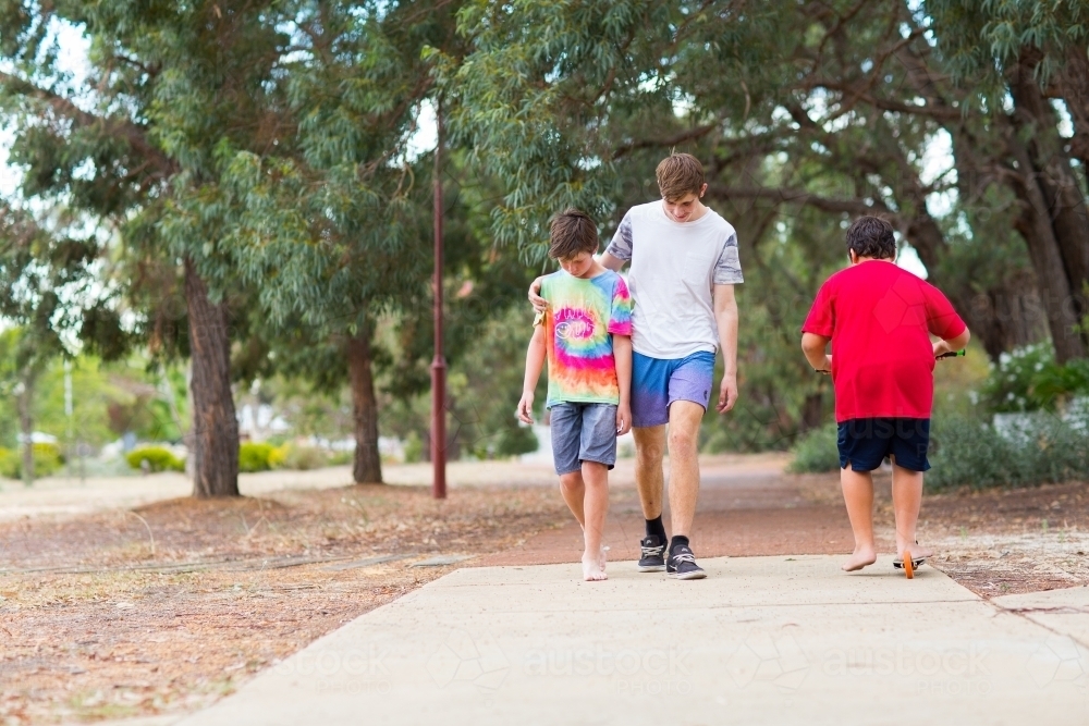 Image of Two boys walking along a path - Austockphoto