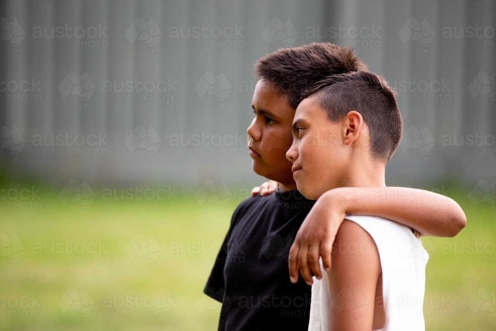 Image of two boys with their arms over each other's shoulder - Austockphoto