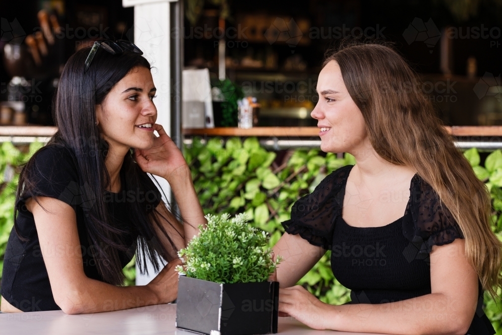 Image of two friends chatting in a cafe - Austockphoto