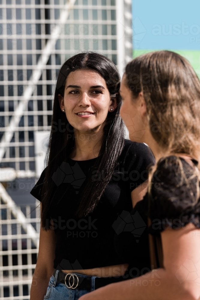Image of two friends chatting outdoors - Austockphoto