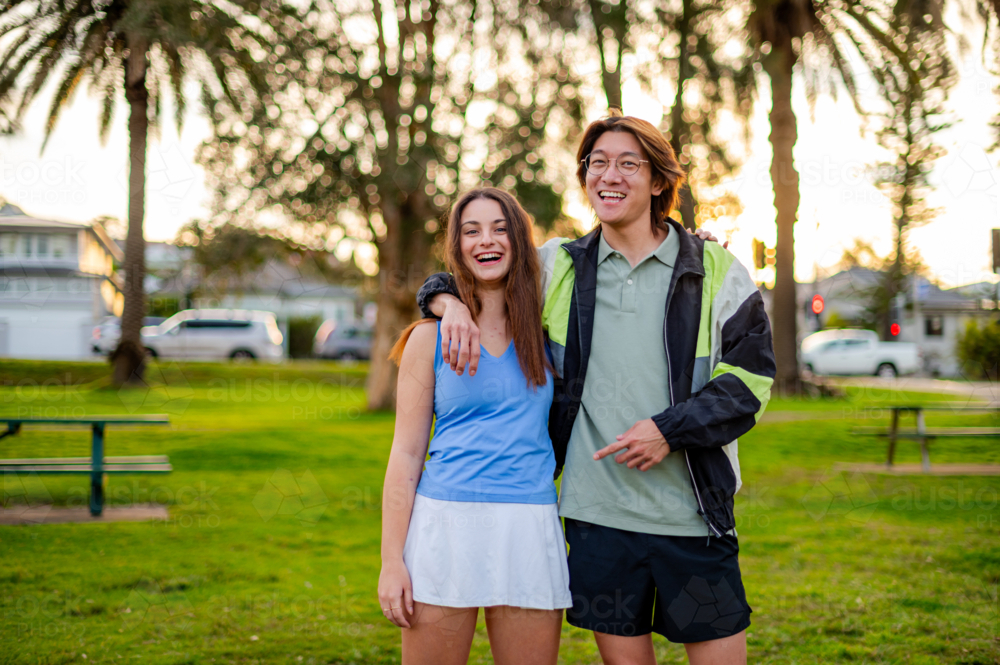 Image of Two friends smiling together in a park, surrounded by palm ...