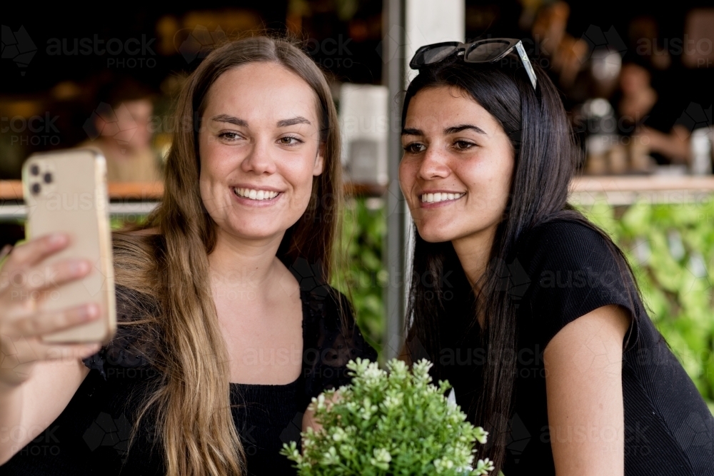 Image of two friends taking a selfie - Austockphoto