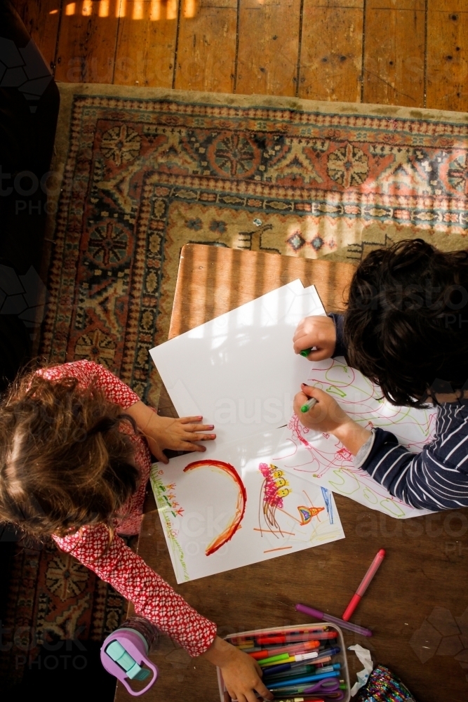 Image of Two girls doing artwork together on table at home during the ...