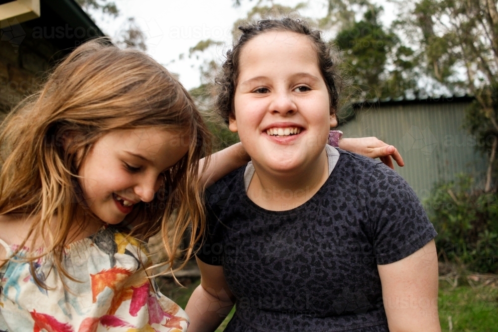 Image of Two happy girls smiling together outside in bushland ...