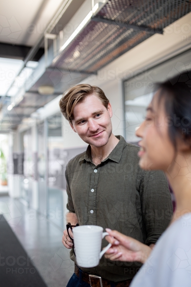 Image of Two happy office workers talking together in an industrial co ...