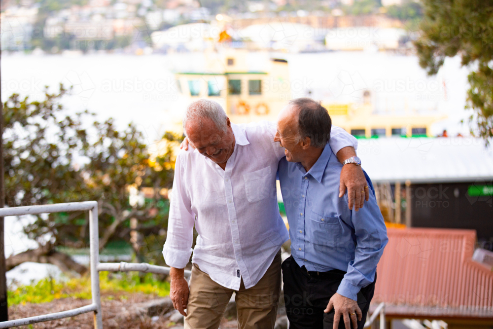 Image of Two happy senior men walking with their arms around each other ...