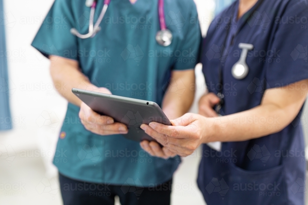 Image of two health care workers looking at a tablet in the clinic ...
