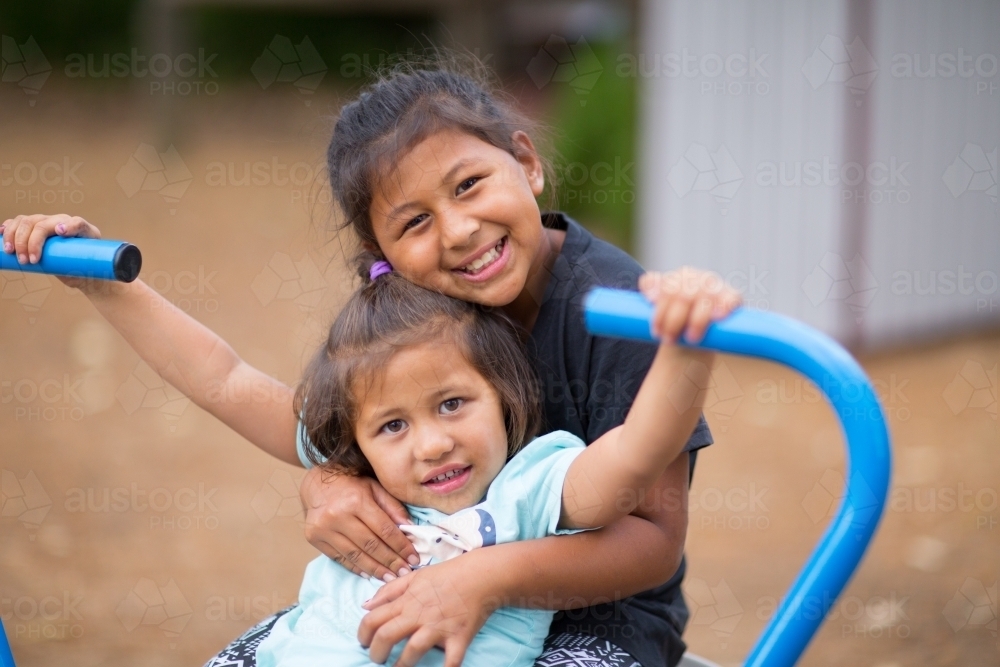 Image of Two Maori children playing on exercise equipment - Austockphoto