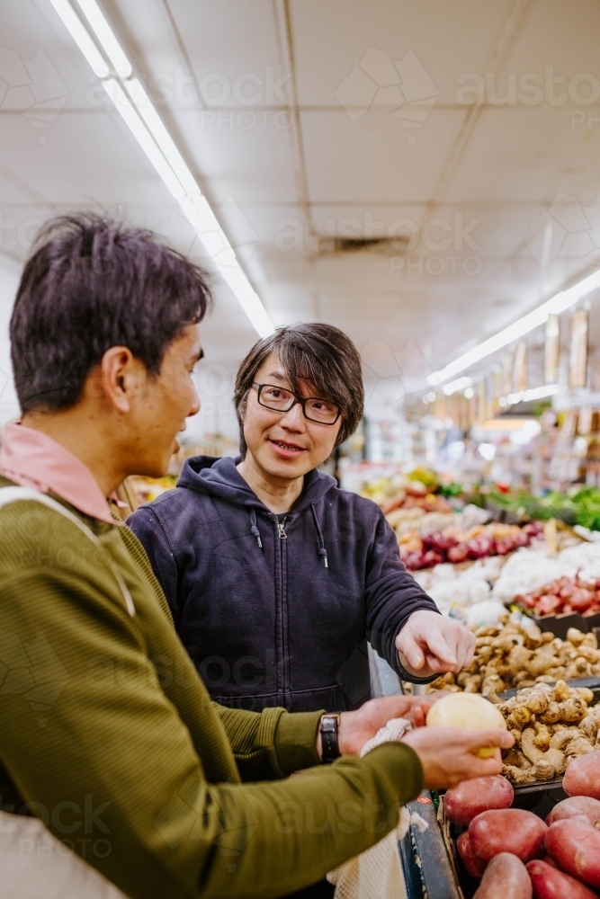 Image of Two men having a conversation in fresh food supermarket ...