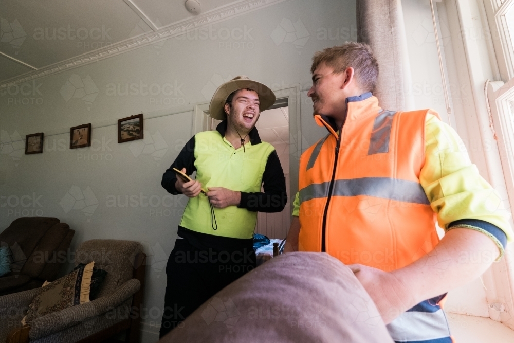 Image of Two Men Sharing a Joke in a Lounge Room - Austockphoto