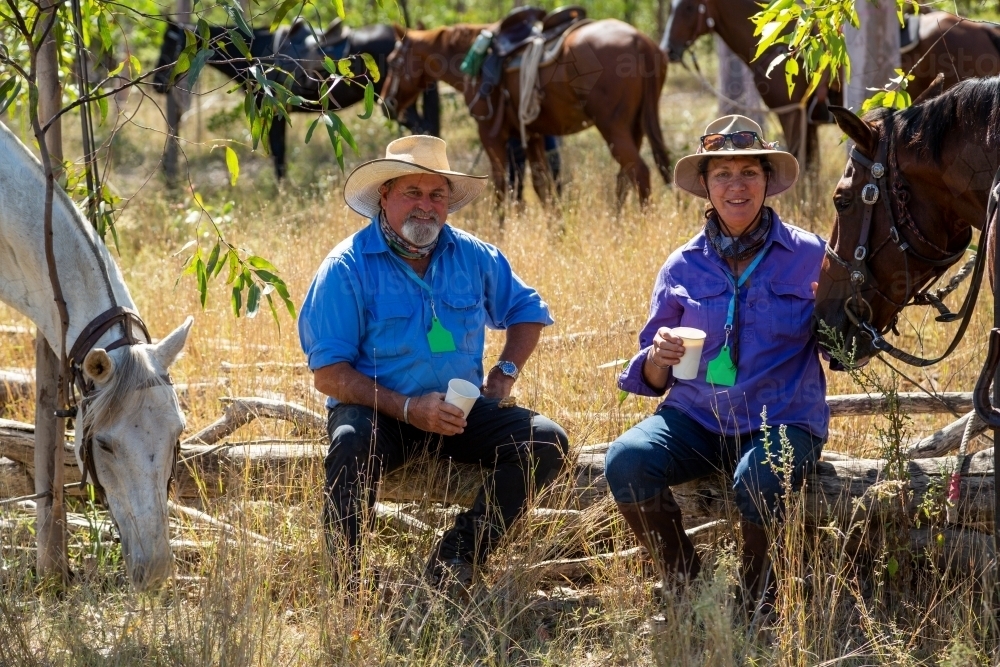 Image of Two middle aged graziers and their horses relaxing during ...