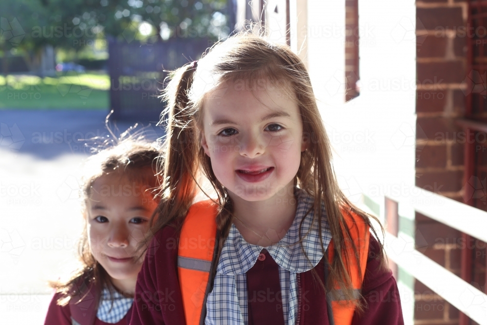 Image of Two school students standing outdoors smiling - Austockphoto