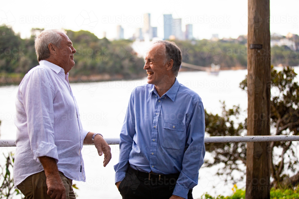 Image of Two senior men talking near the harbour one leaning on the ...