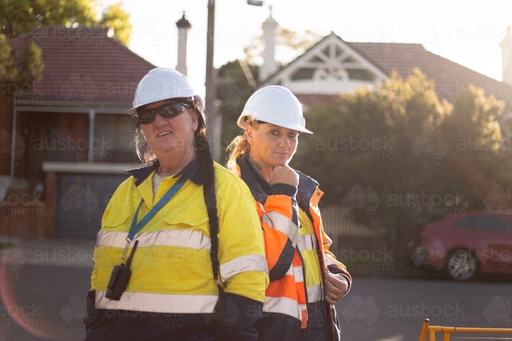Image of Two smiling women road workers wearing white helmet with high ...