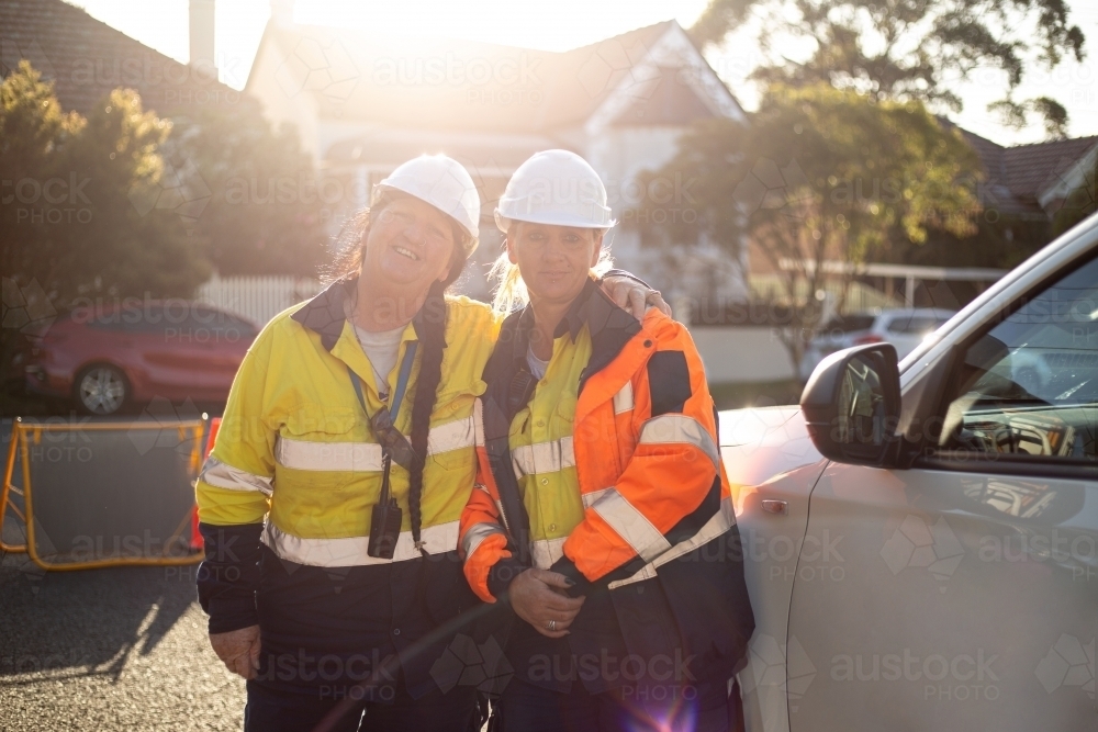 Image of Two smiling women road workers wearing white helmet with ...