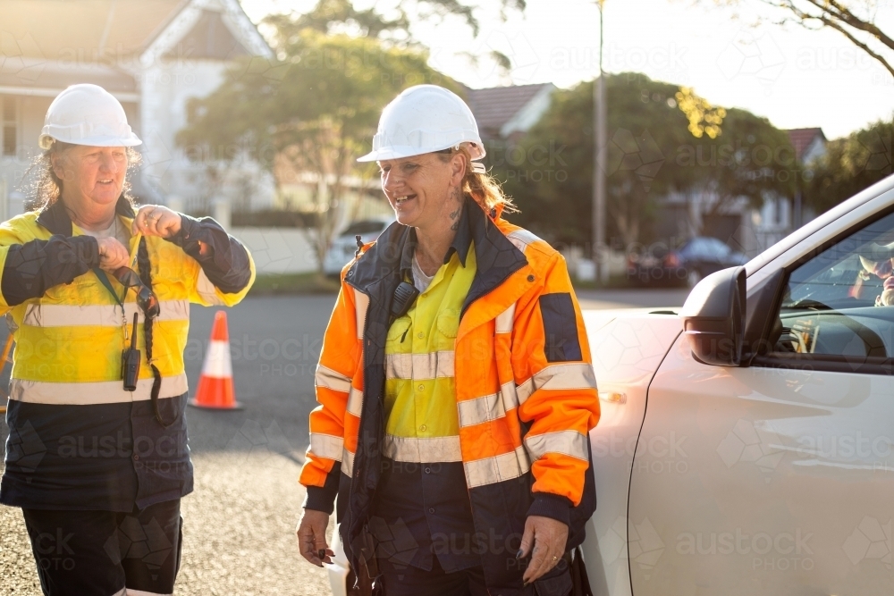 Image of Two smiling women road workers wearing white helmet with ...