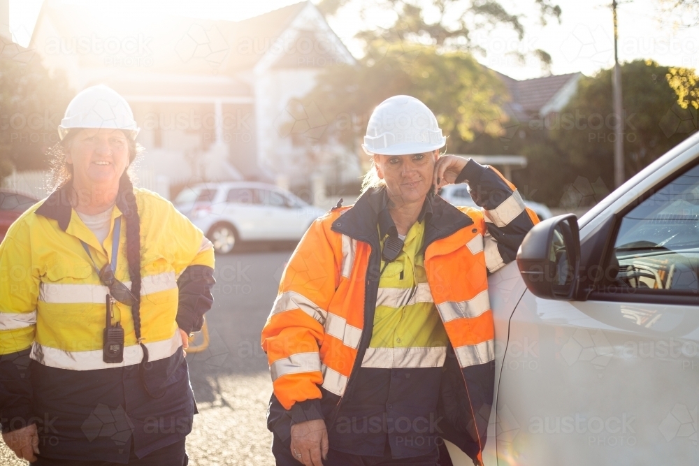 Image of Two smiling women road workers wearing white helmet with ...