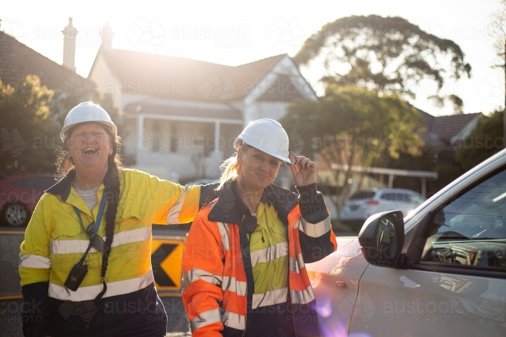 Image of Two smiling women road workers wearing white helmet with ...