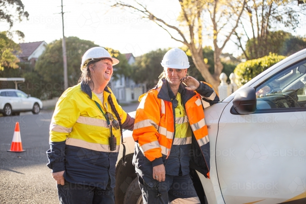 Image of Two smiling women road workers with white helmet and high vis ...