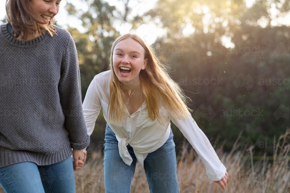 Image of two teenage girls holding hands in natural setting - Austockphoto