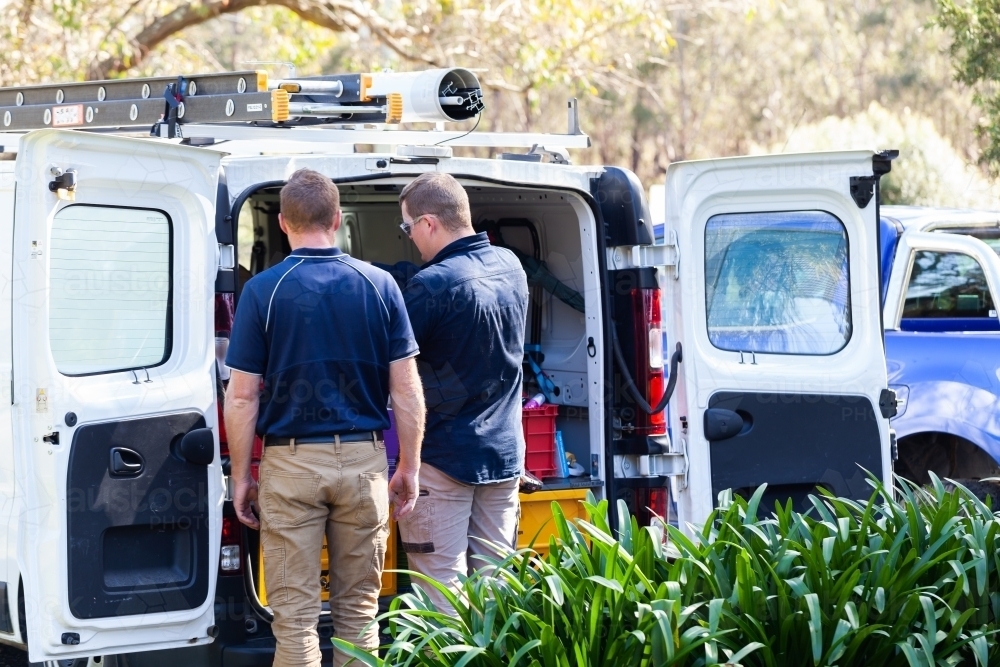 Image of Two tradesmen and their vehicle - Austockphoto