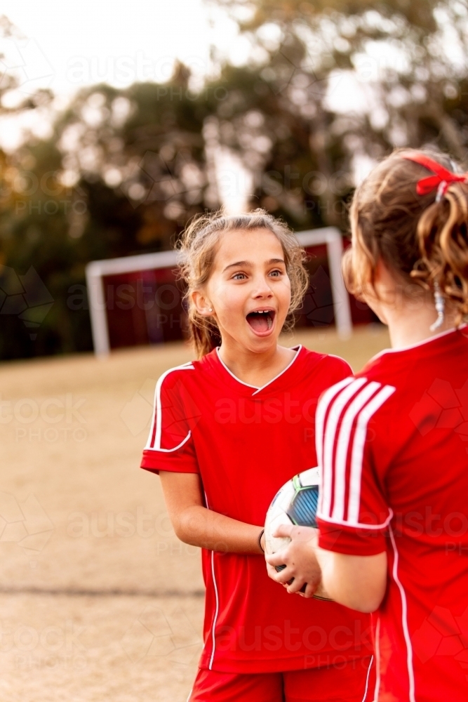 Image of Two tween football players standing together at a sports oval ...
