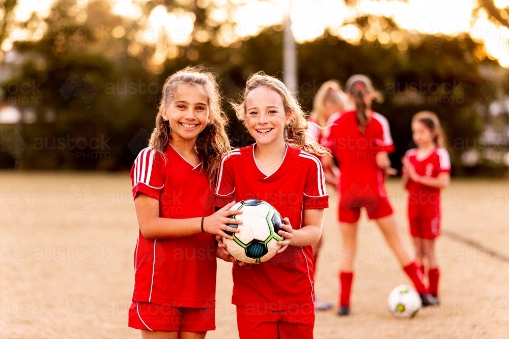 Image of Two tween football players standing together at a sports oval ...