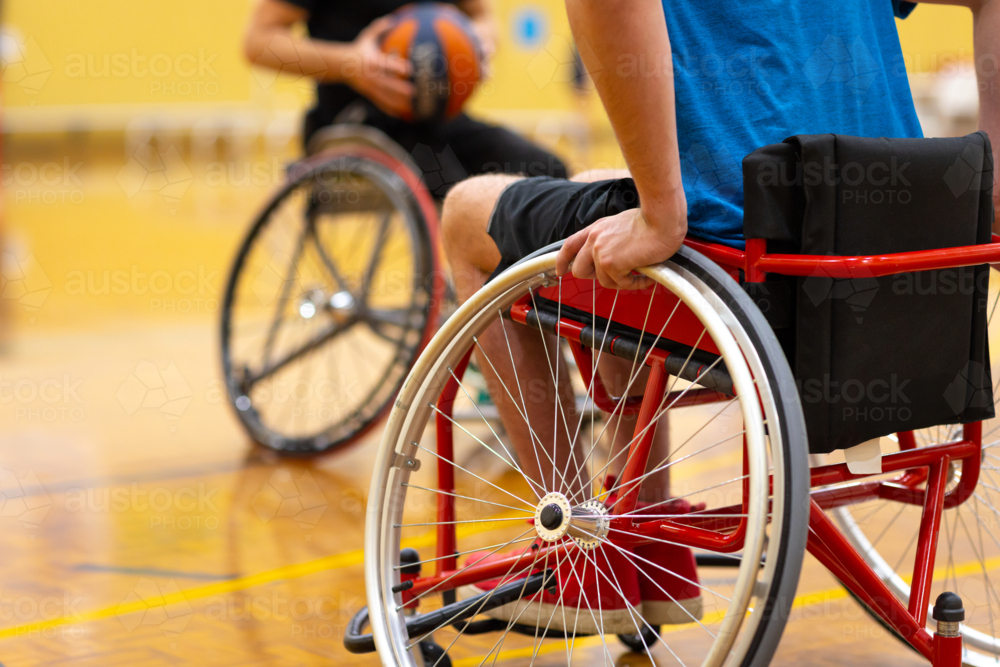 Image of two wheelchairs support players on a basketball court and one ...